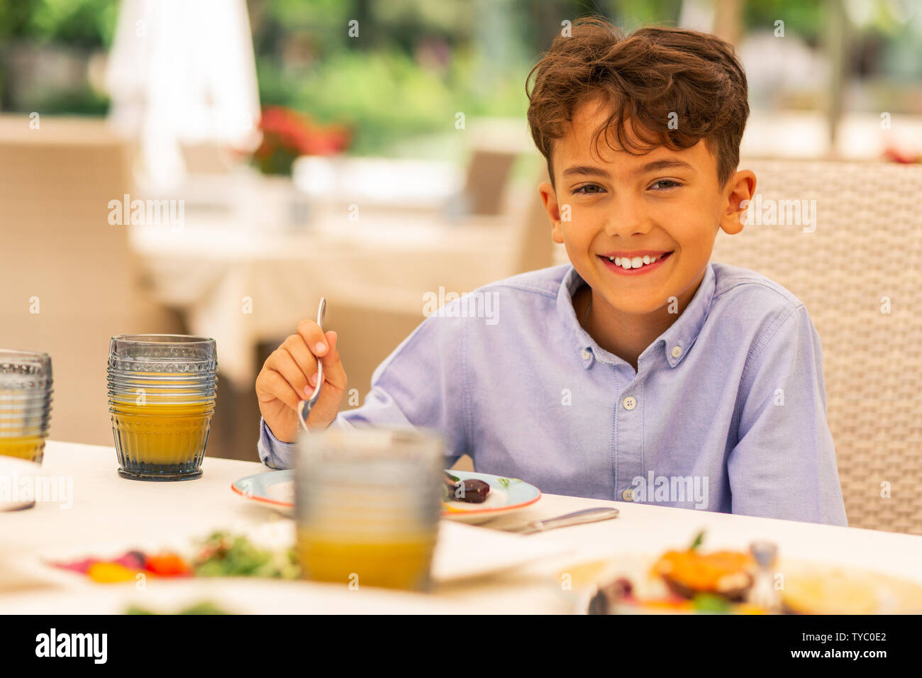 Handsome boy smiling while enjoying breakfast Stock Photo - Alamy