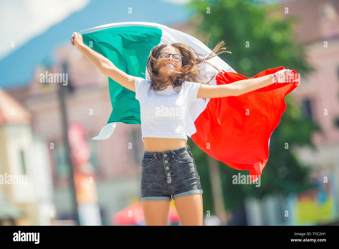 Happy girl tourist walking in the street with italian flag Stock Photo ...