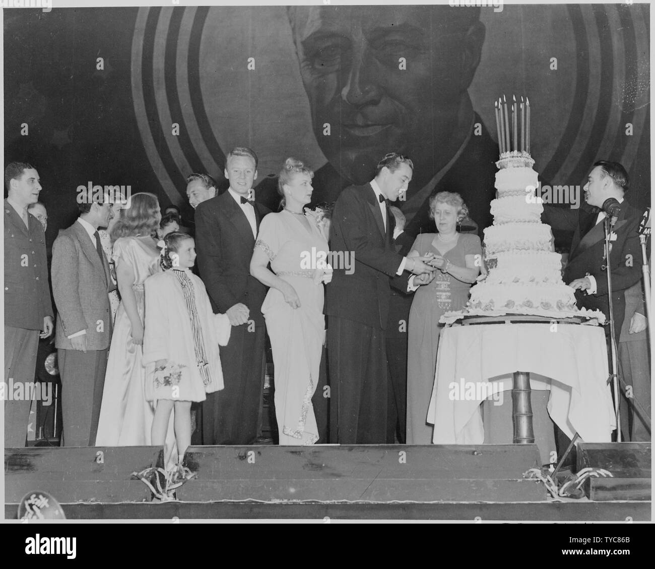 Photograph of First Lady Bess Truman giving actor Cesar Romero a slice ...