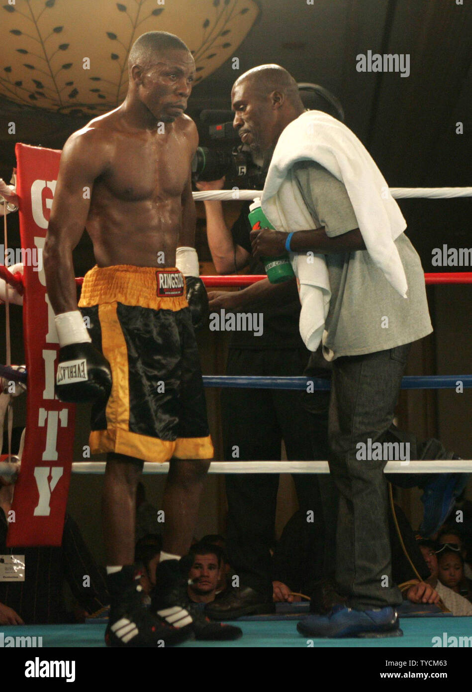 IBA Featherweight champion Cornelius Lock of Detroit, is instructed between rounds by trainer ...
