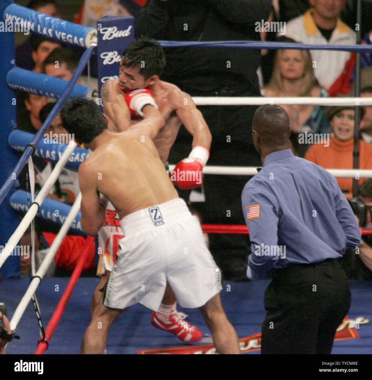 As referee Kenny Bayless looks on, Manny Pacquiao of the Philippines ...