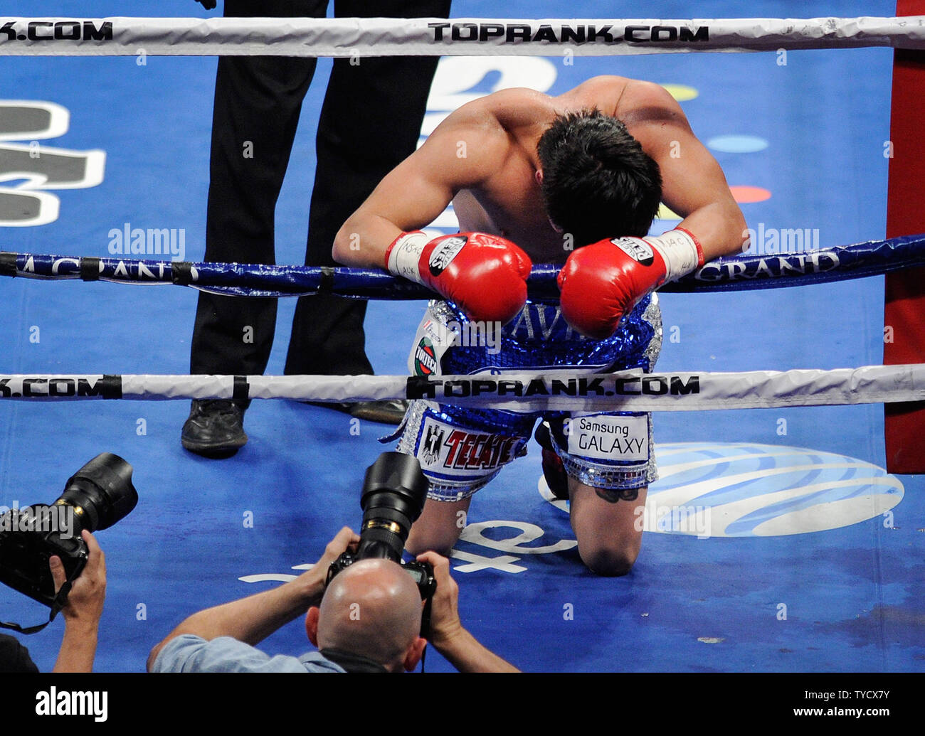 Boxer Jorge Arce of Mexico, kneels in the corner after being hit by ...