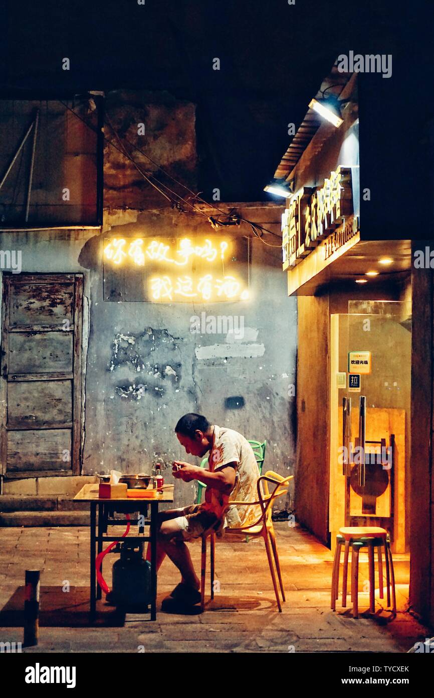 People who eat alone on the street at night Stock Photo - Alamy