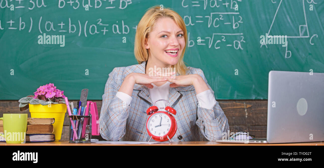 always happy. teacher with alarm clock at blackboard. Time. woman in ...