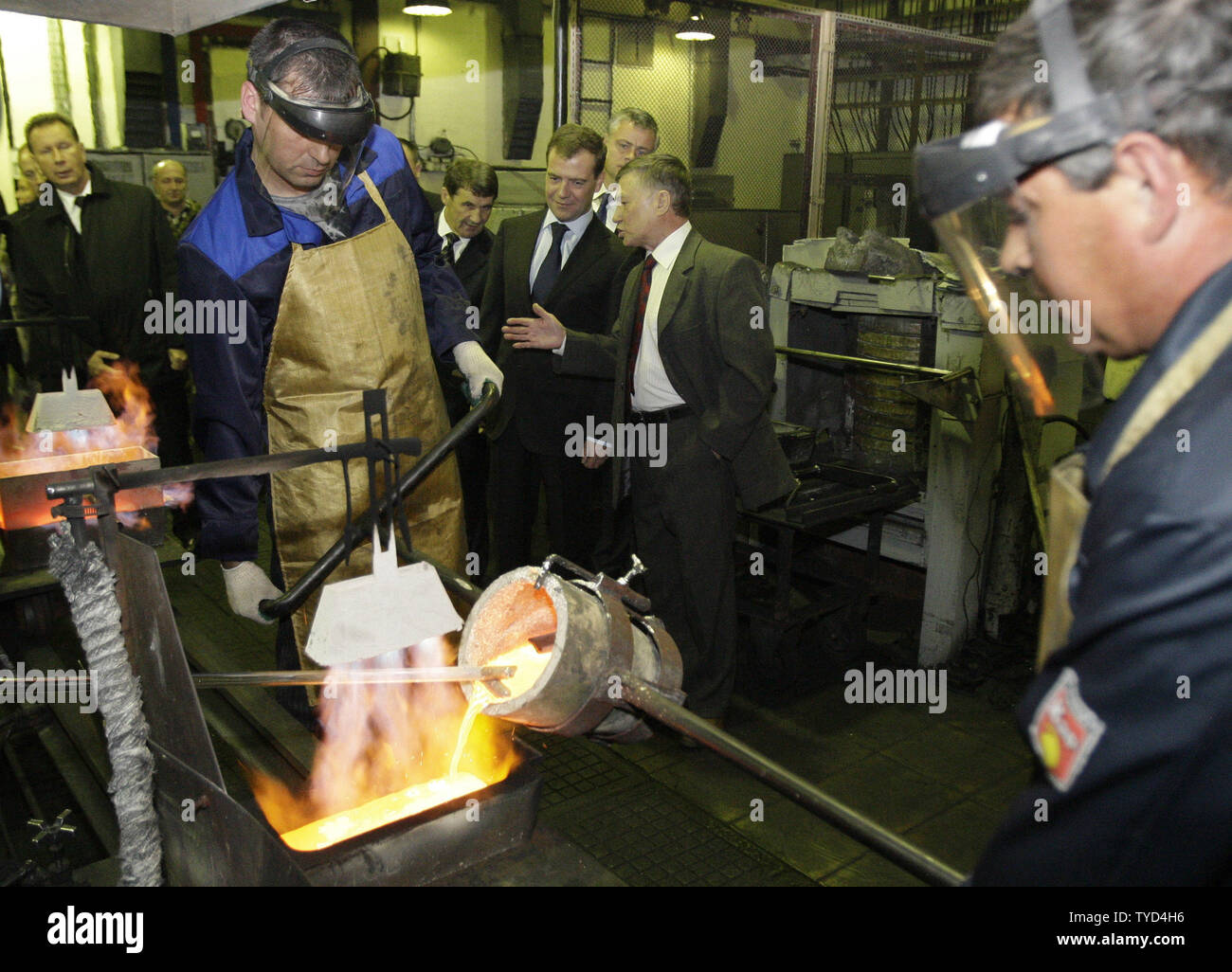Russian President Dmitry Medvedev (C) inspects a worker as he makes a ...