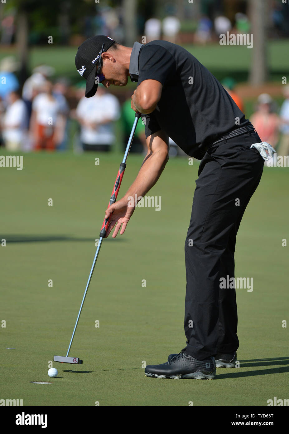 Adam Scott putts on the second green using his belly putter in the ...