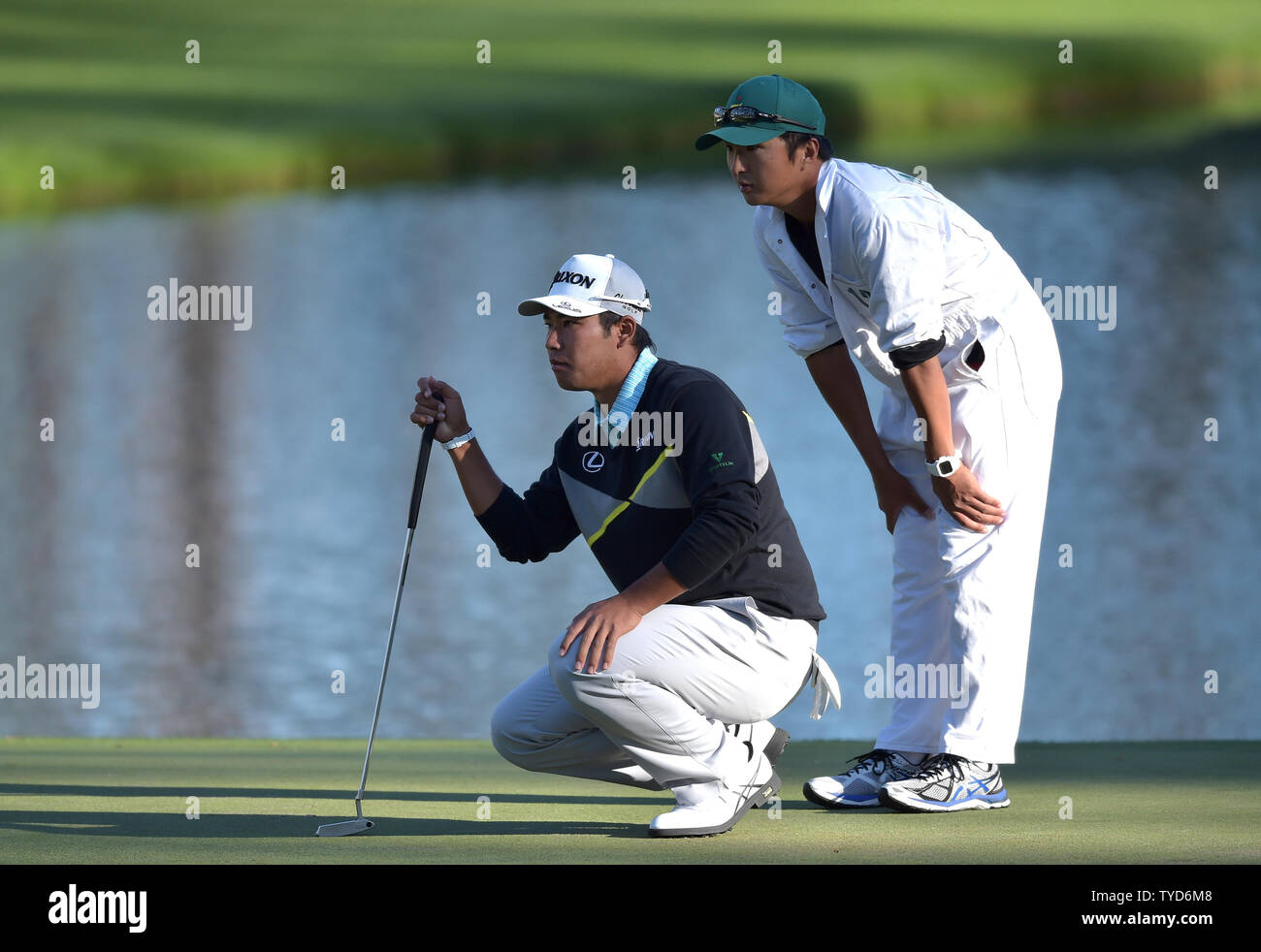 Hideki Matsuyama of Japan and caddie Daisuke Shindo line up a putt on ...