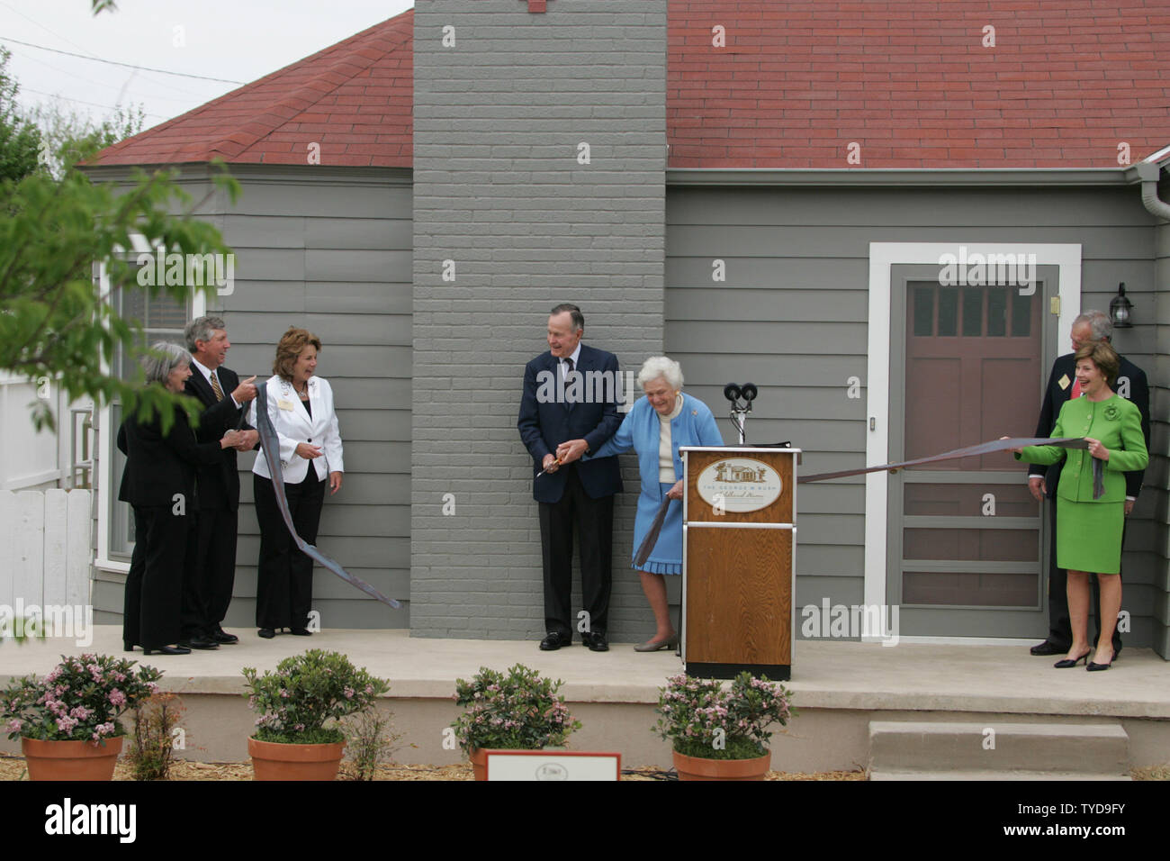 Former President George H. W. Bush and Barbara Bush (C) cut the ribbon ...