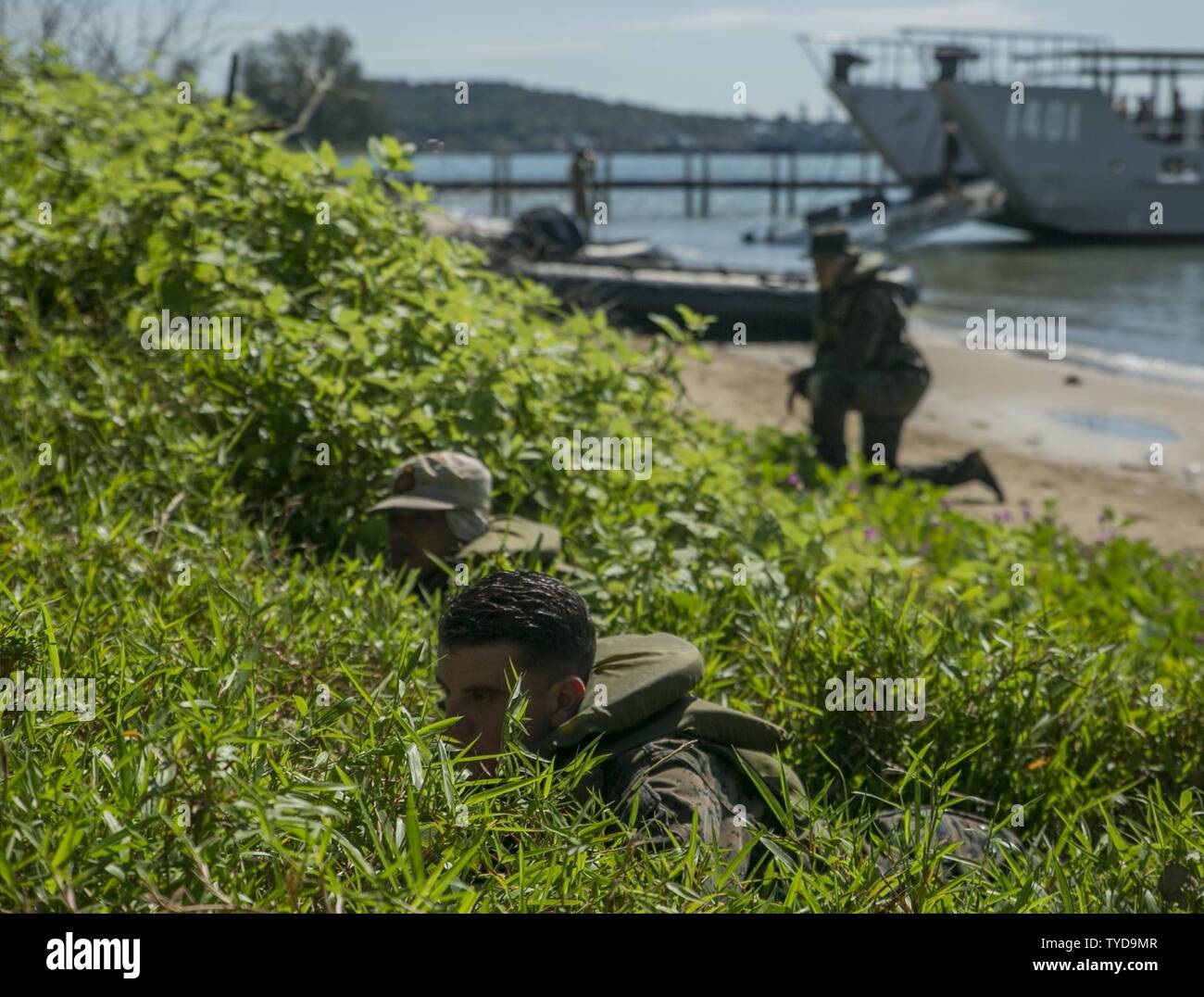 U.S. Marine Lance Cpl. Clayton Osteen (front) provides security with a ...