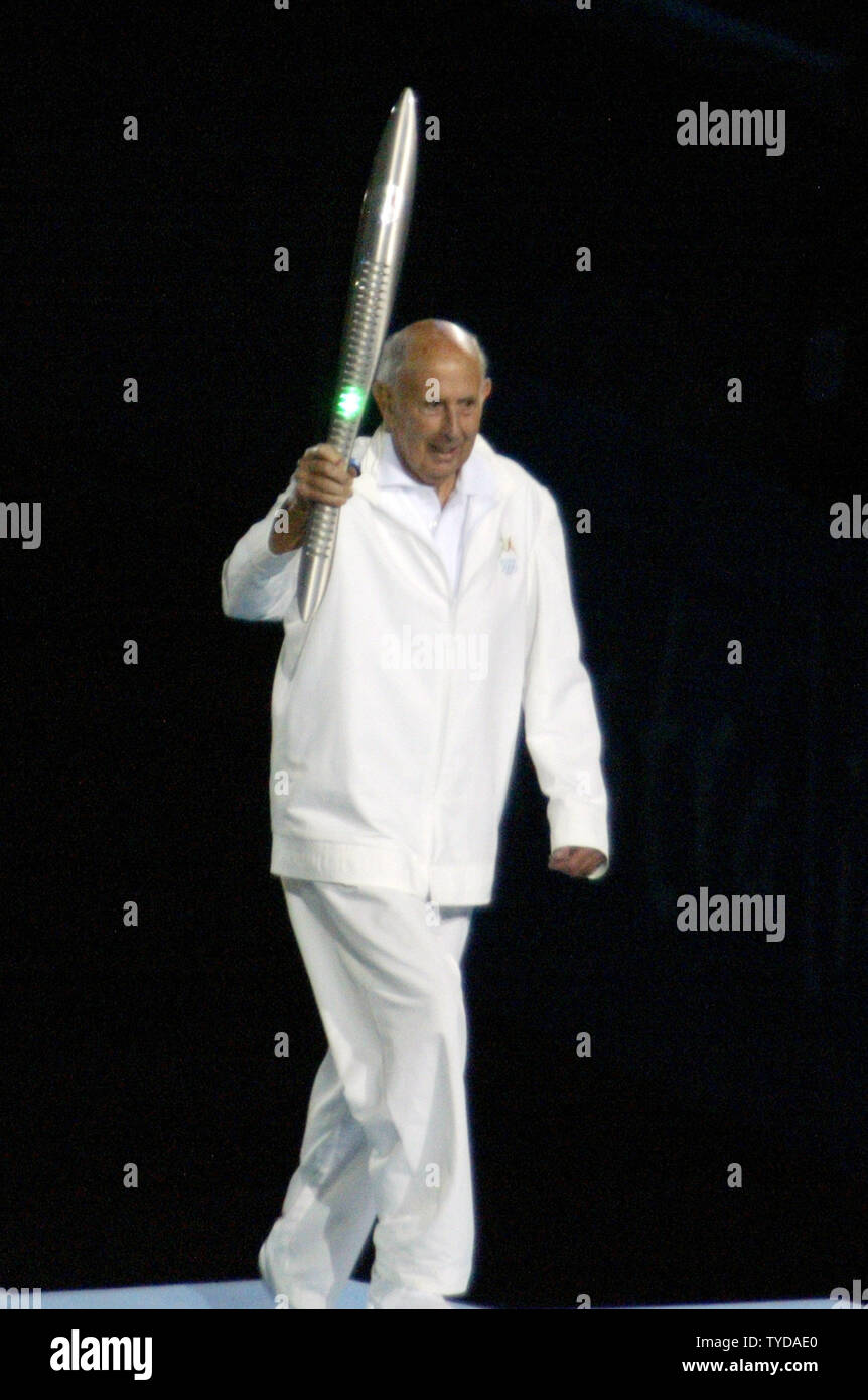 The final Queen's baton relay runner, John Landy, travels up the stairs ...