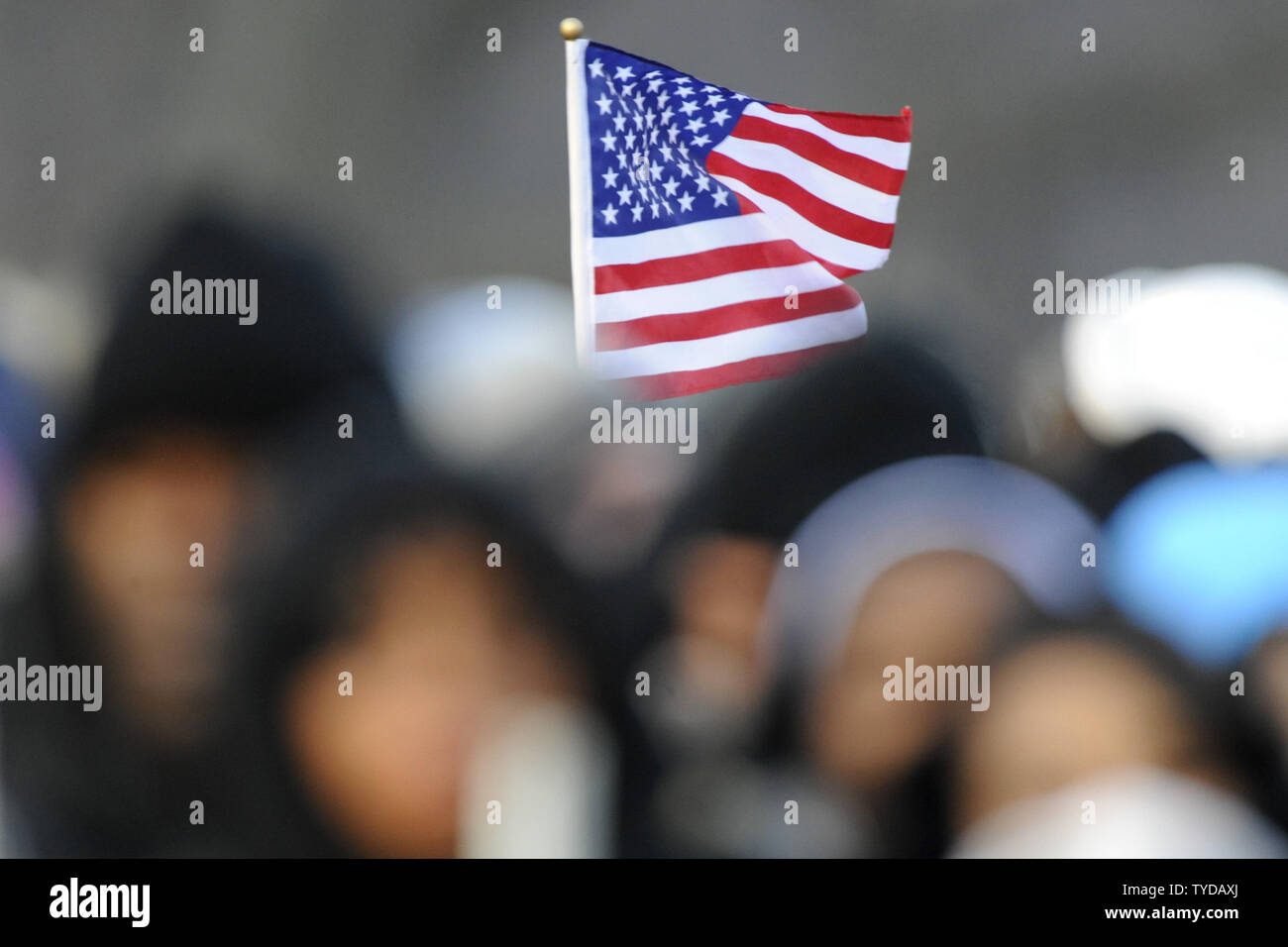 An American flag is held above the crowd as Barack Obama is sworn in as ...