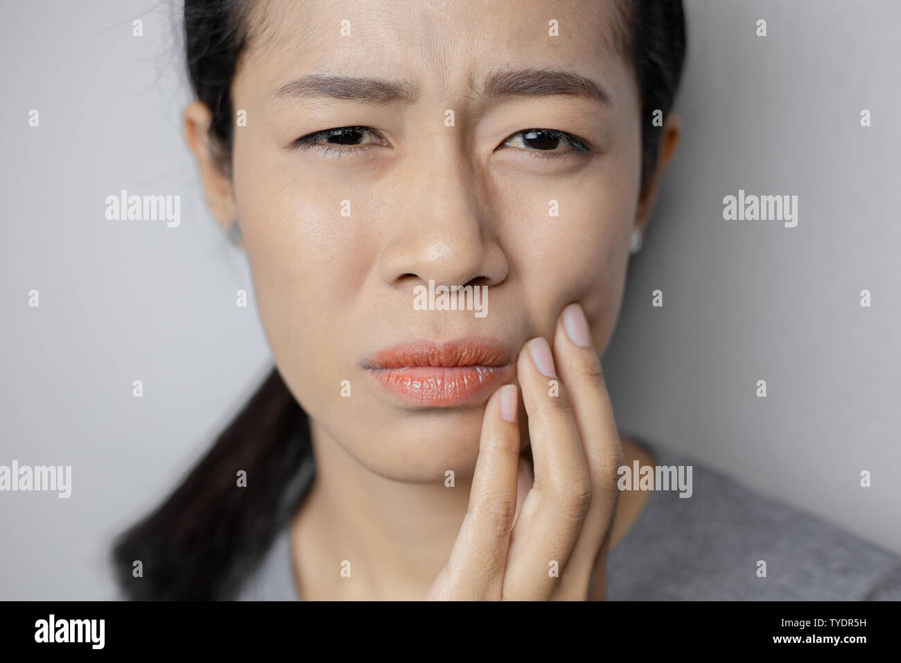 Woman put her hand on her cheek due to toothache. Asian woman is ...