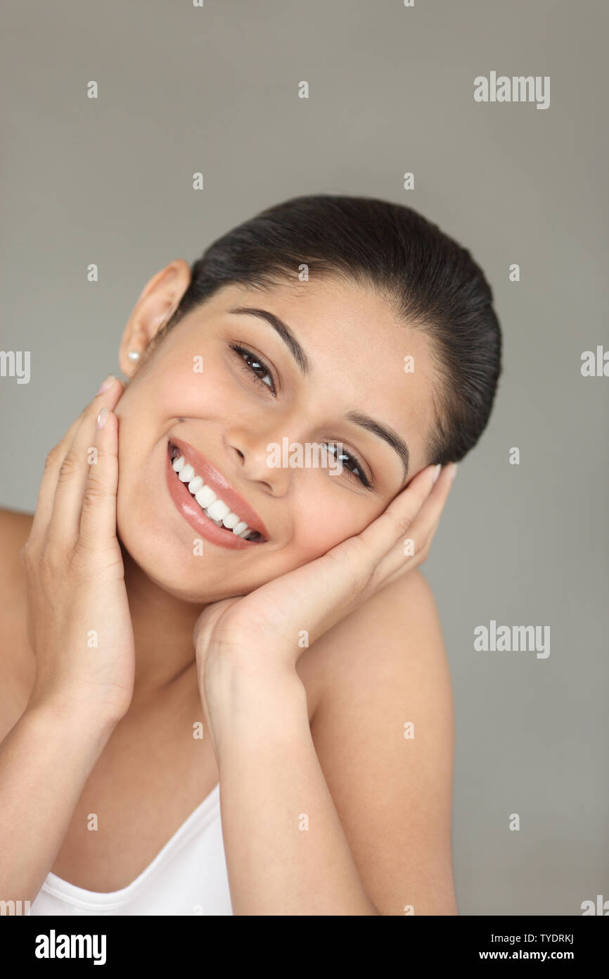 Portrait a woman touching her cheeks and smiling Stock Photo - Alamy
