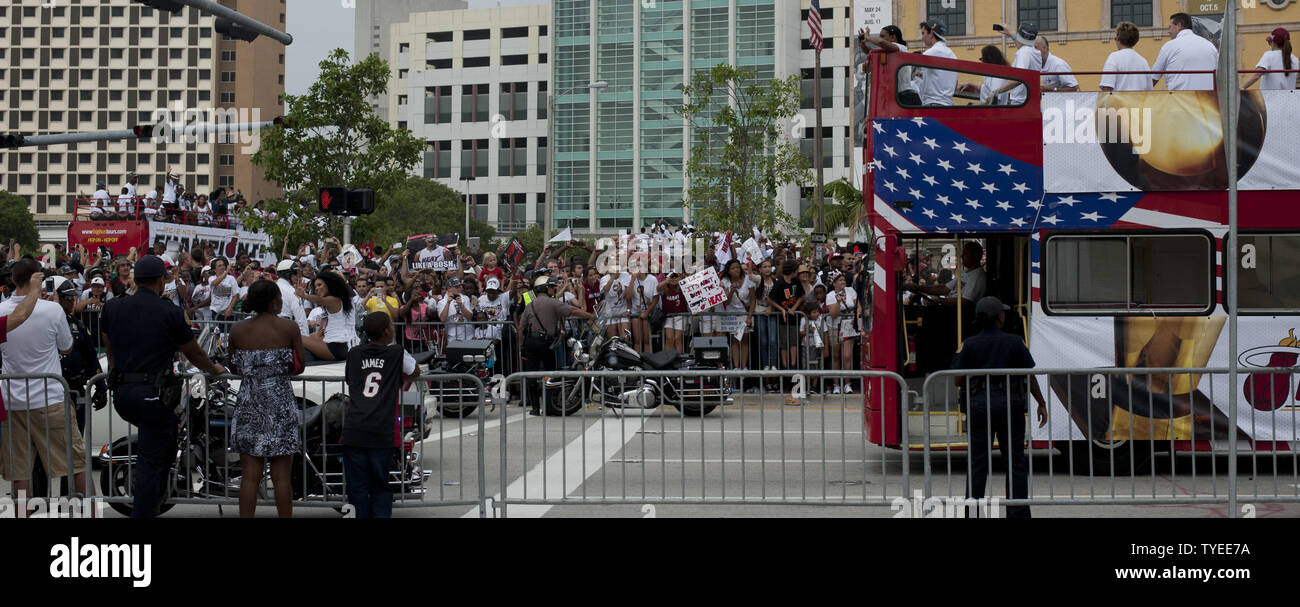 Miami Heat fans crowd the streets as the first of the Heat payer buses ...