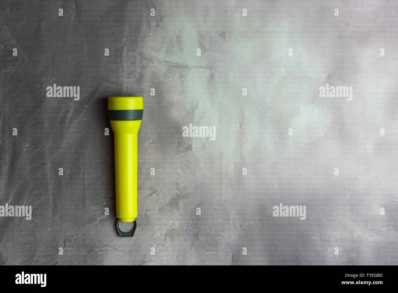 Yellow color torch or flashlight, isolated on grunge or grey background ...