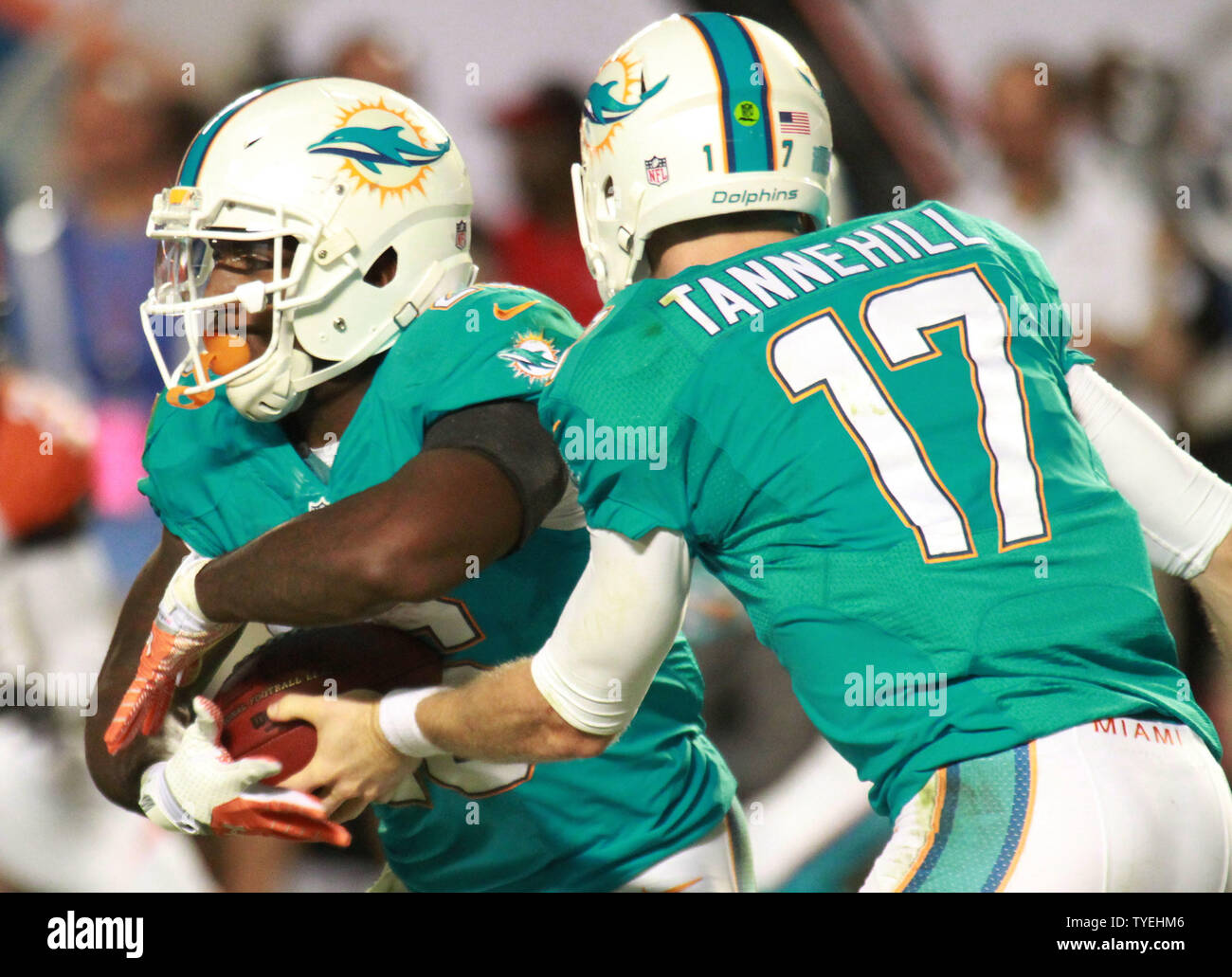 Miami Dolphins RB Lamar Miller (L) takes the ball 41 yards against the ...