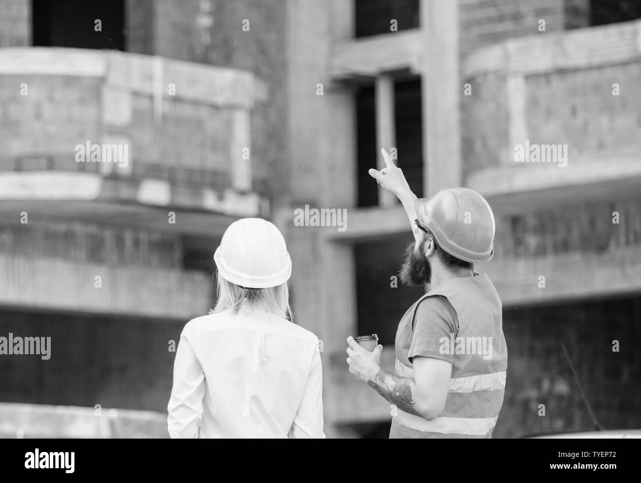 Discussing plan. Woman engineer and builder communicate at construction ...