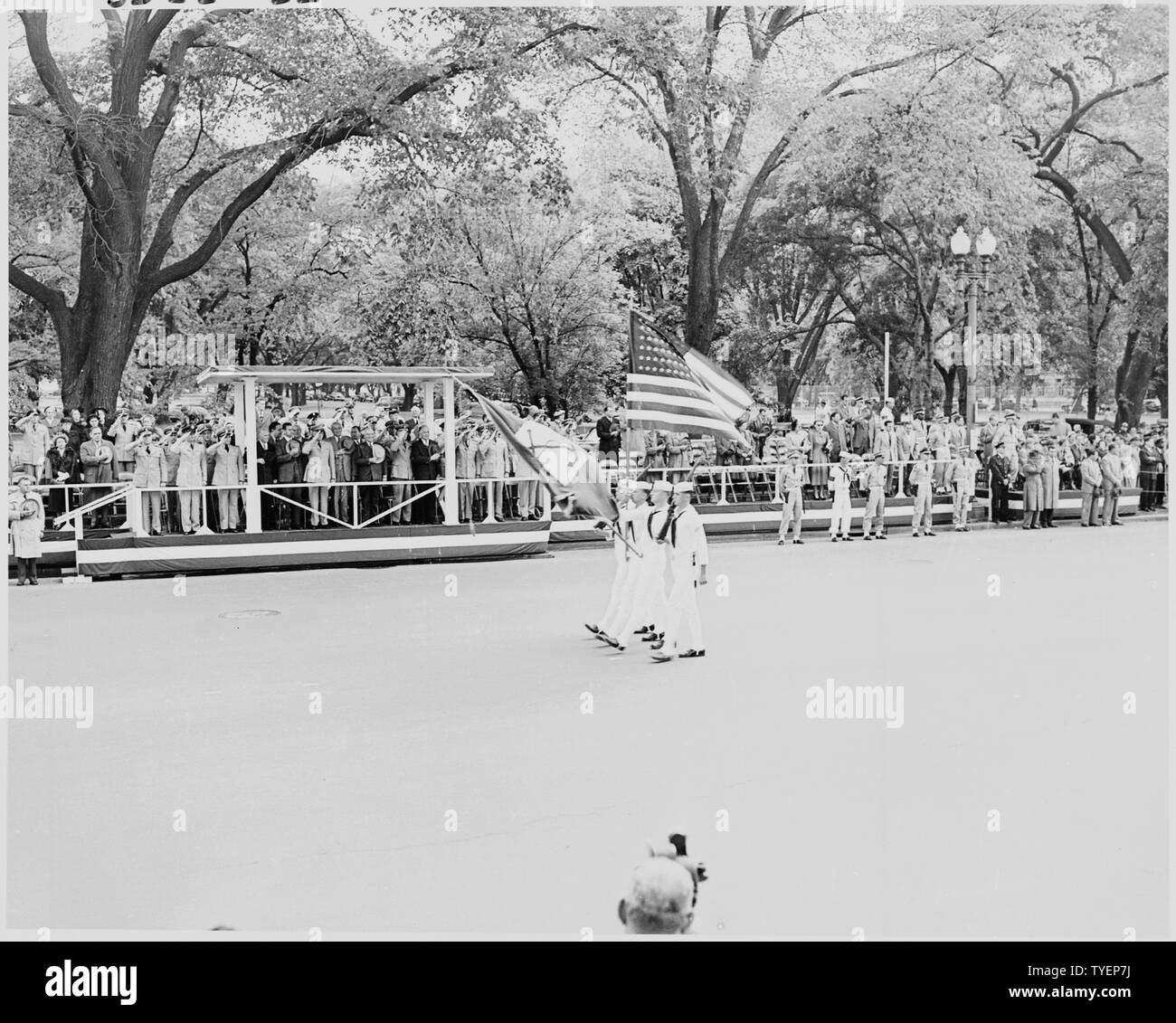 Photograph of a color guard passing the reviewing stand during the ...