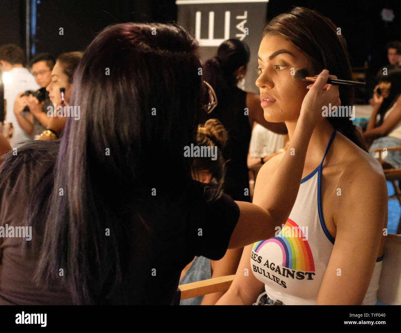 A runway model has makeup and hair done backstage during the Funkshion ...