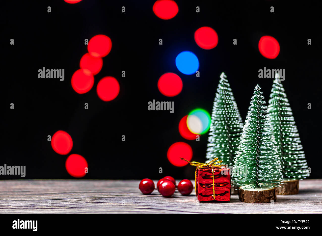 Christmas gift box under pine trees, on wooden table on background of ...