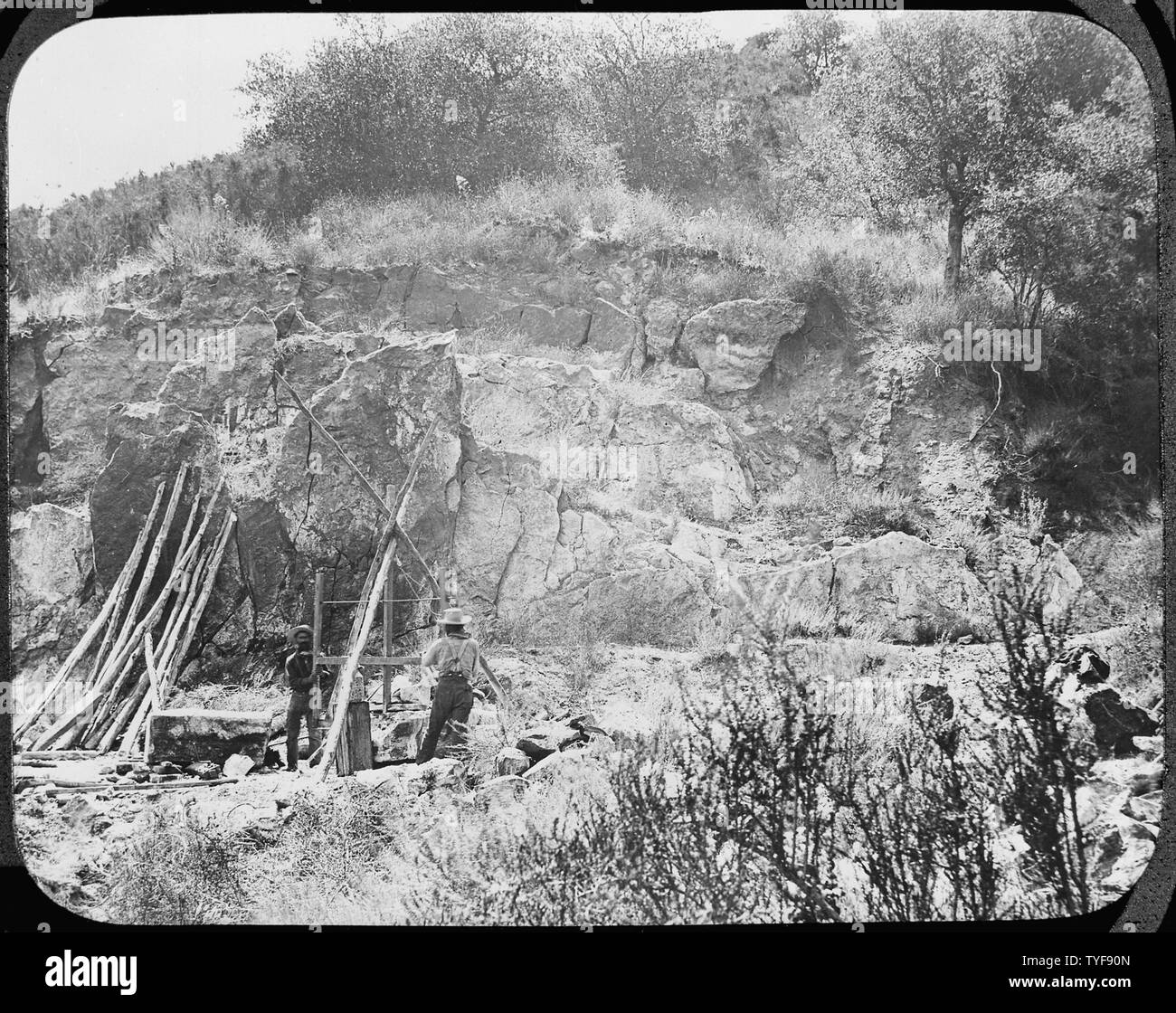 Photograph of two men starting up a vertical mine shaft underneath a ...