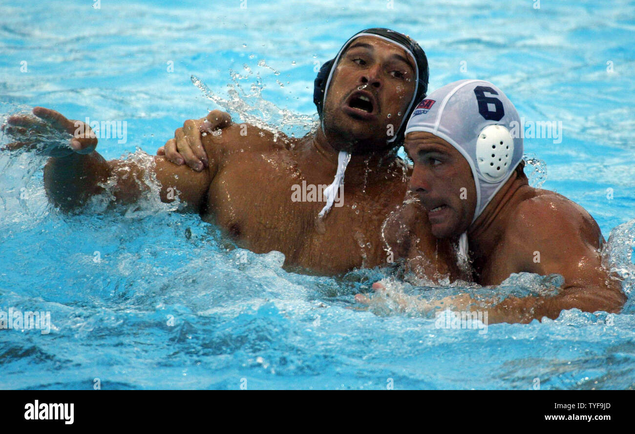 American Peter Hudnut (right) holds Germany's Thomas Schertwitis in a men's water polo quarter ...