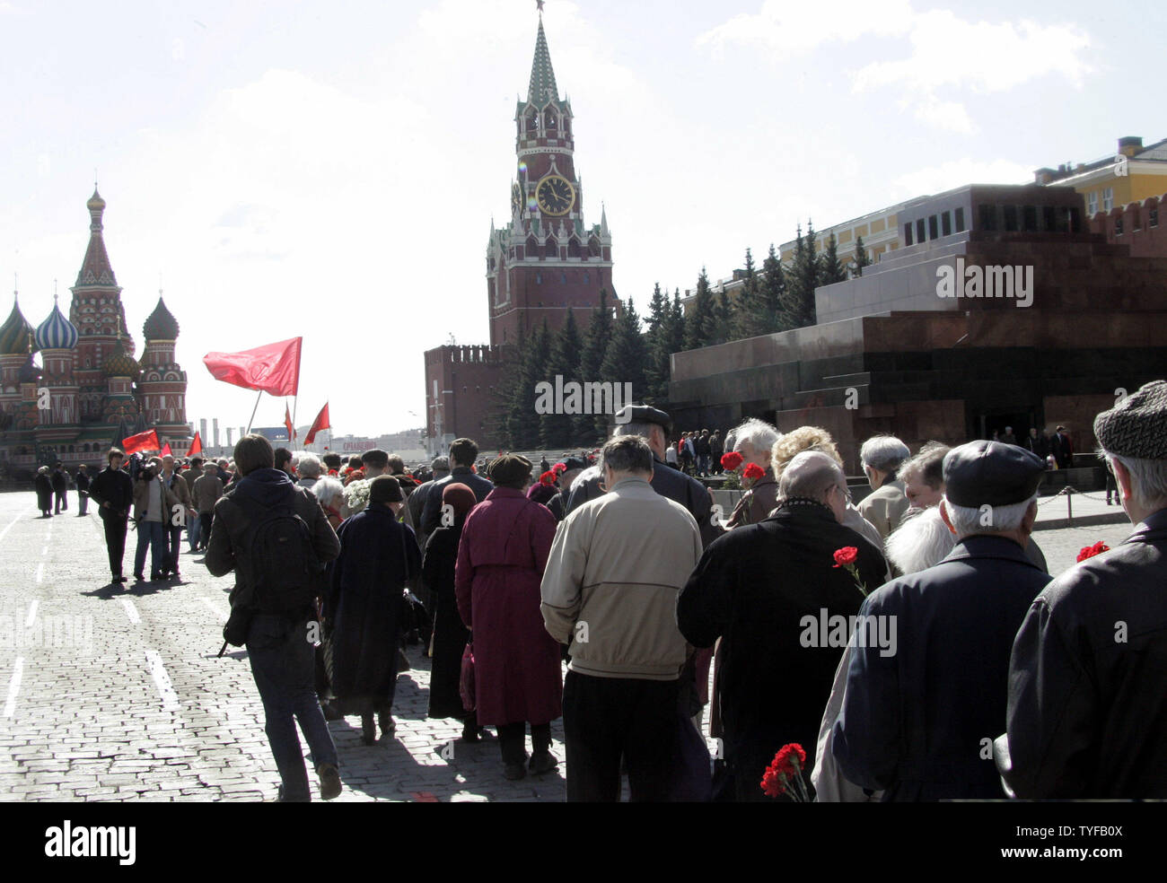 Russian Communist supporters walk with Soviet flags across Red Square ...