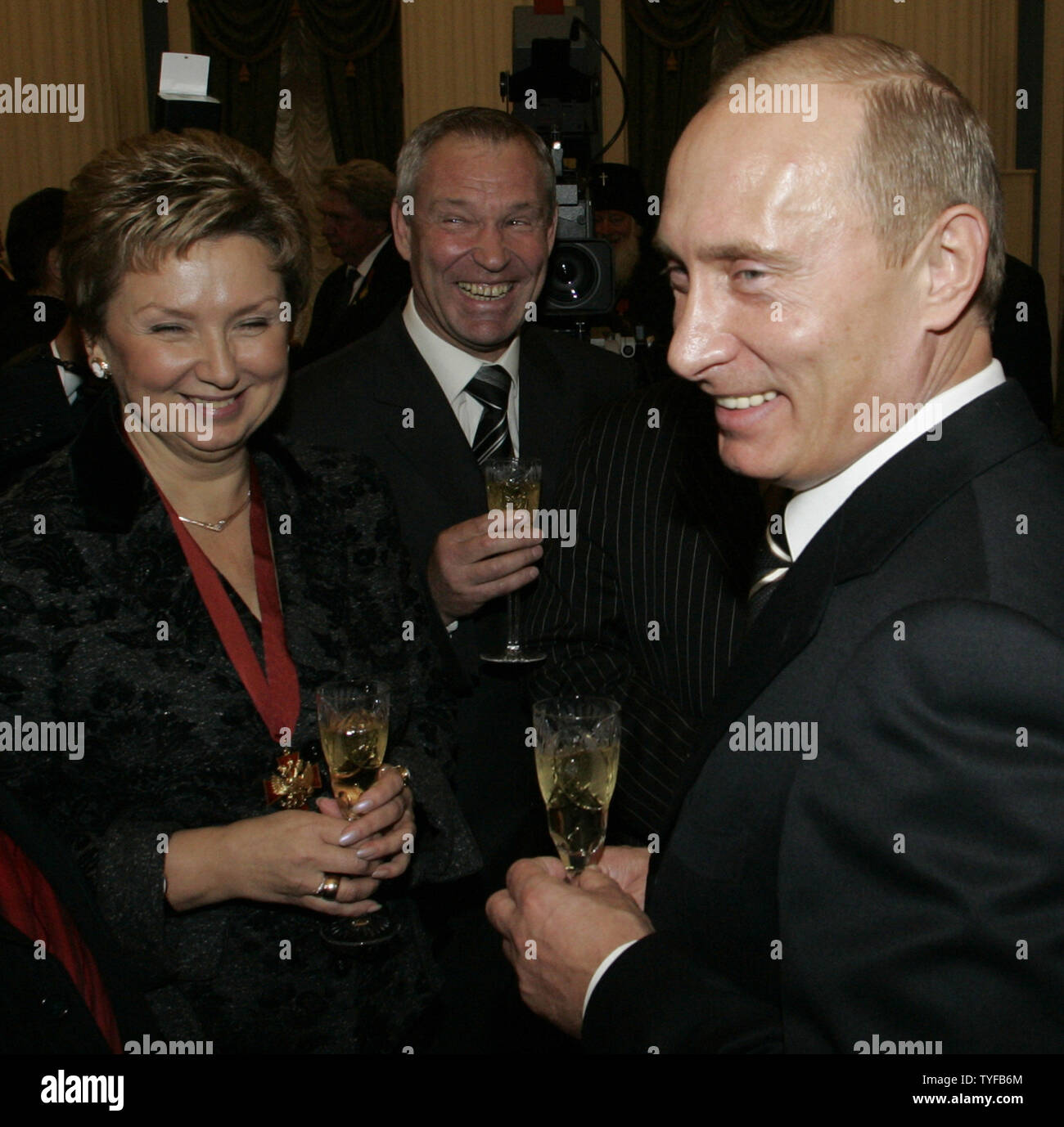 Russian President Vladimir Putin (R) holds a glass of wine after award ...