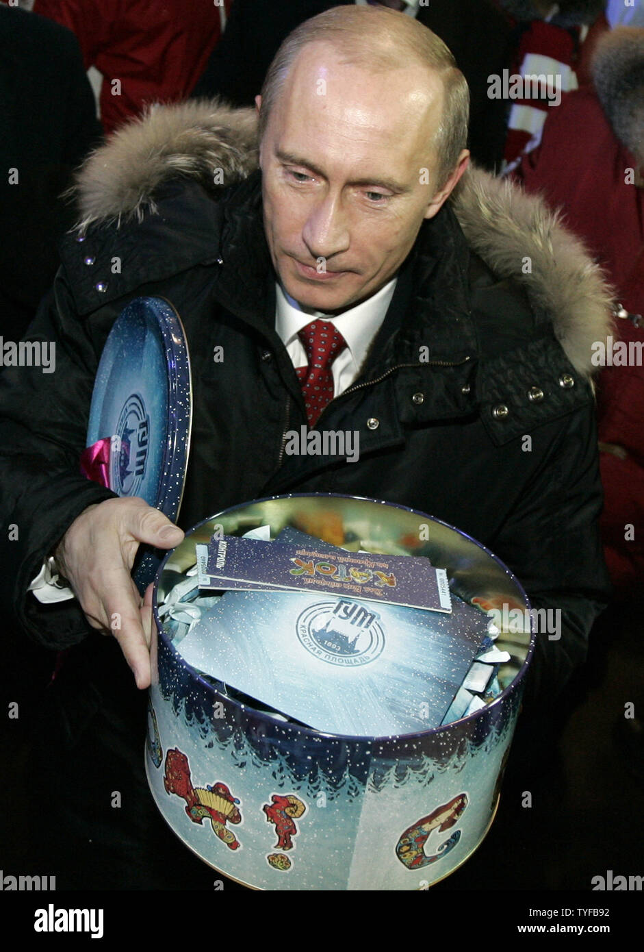Russian President Vladimir Putin opens a can of chocolate candies for ...