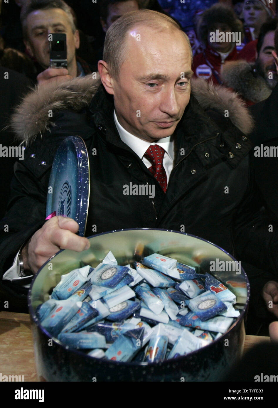 Russian President Vladimir Putin opens a can of chocolate candies for ...