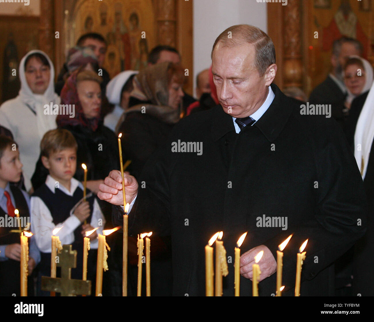 Russian President Vladimir Putin places a candle during a memorial ...