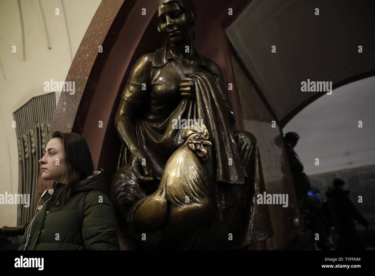 A woman waits next to Soviet era sculptures on the platform of ...