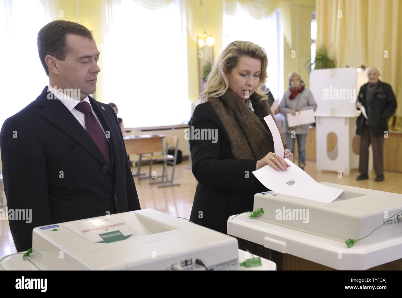 Russian President Dmitry Medvedev looks as first lady Svetlana casts ...