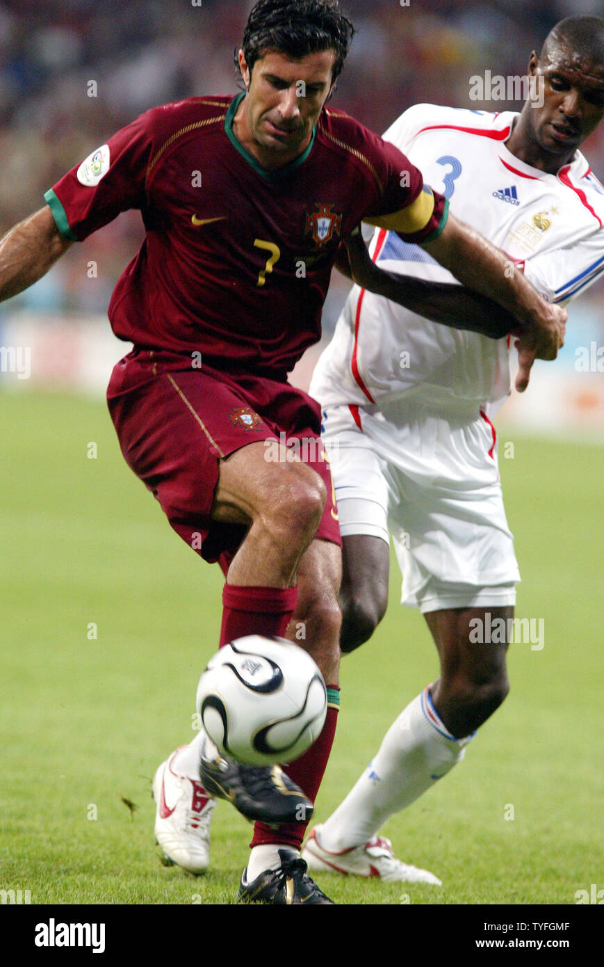 Portugal's captain Luis Figo (7) keeps the ball away from Eric Abidal ...