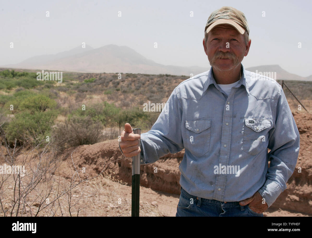 Rancher John Ladd poses for picture with the fence that the Minutemen ...
