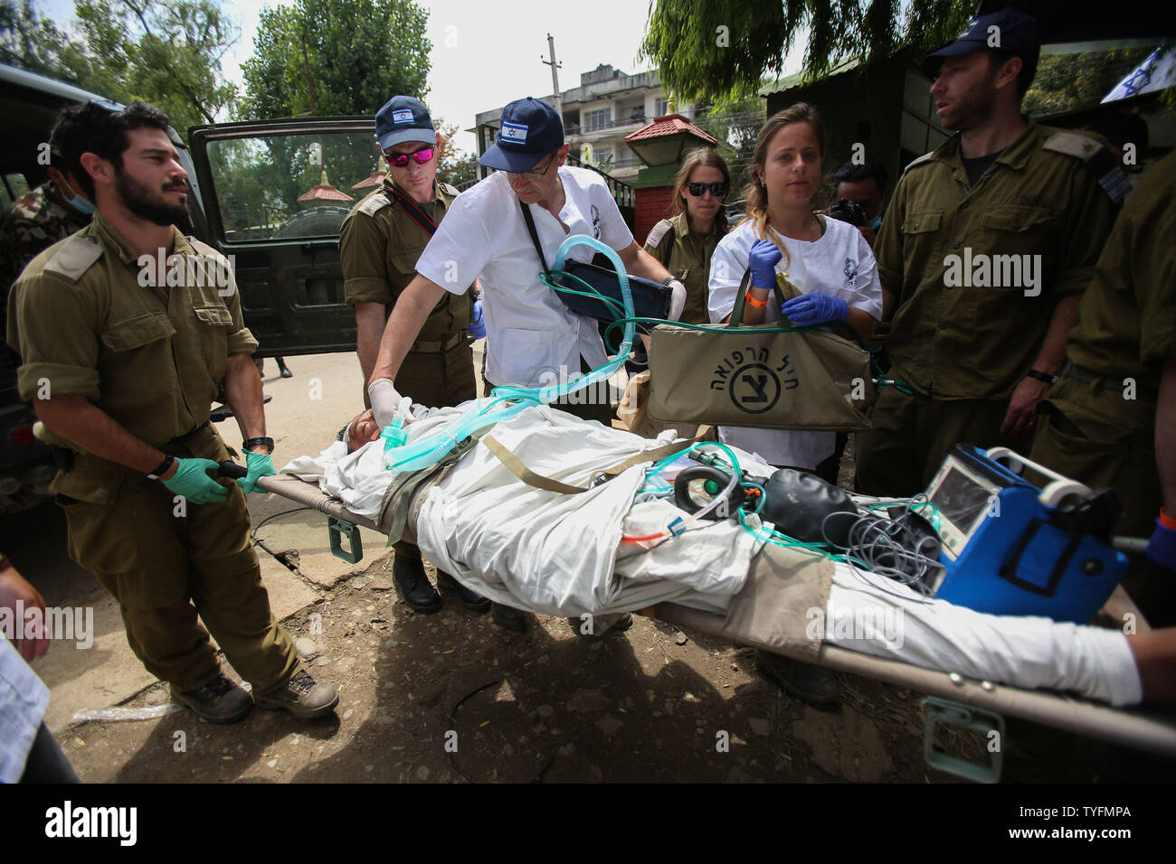 An injured Nepalese man is carried on a stretcher before being treated ...