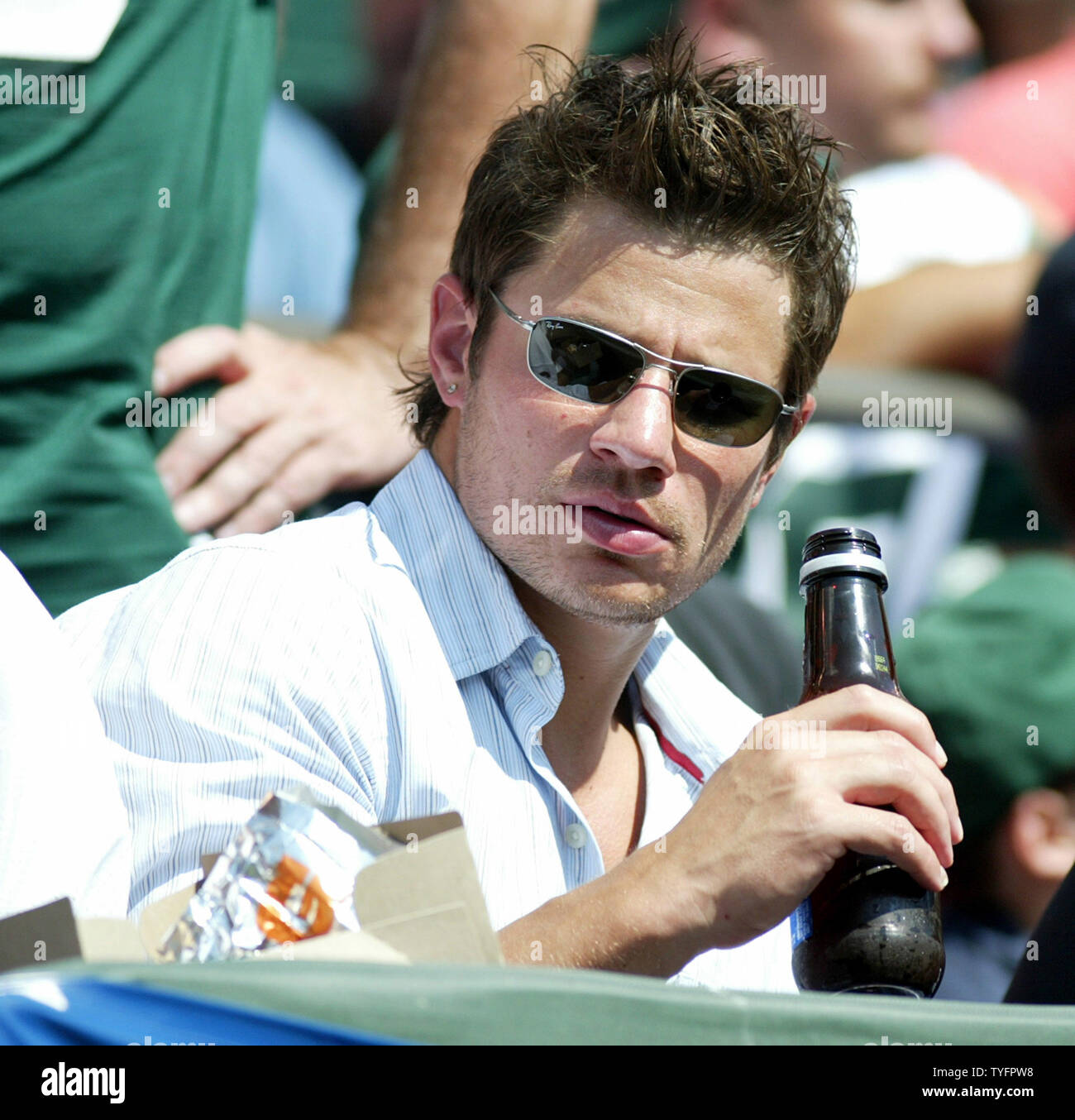 Nick Lachey enjoys a beer while watching the New York Jets play the ...