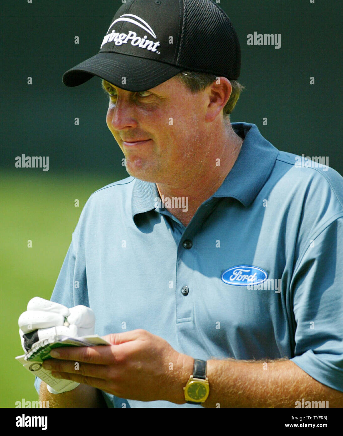 Phil Mickelson smiles while making an entry on his score card during ...