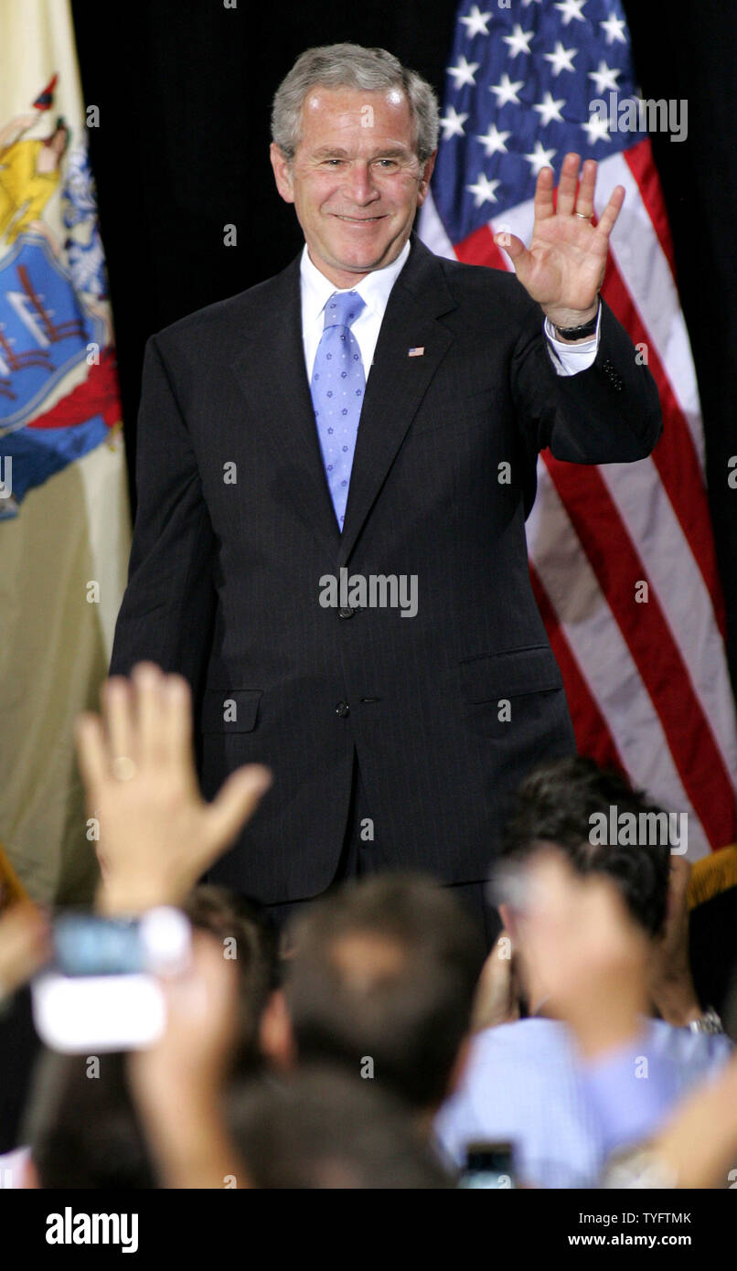 U.S. President George W. Bush waves to cheering supporters as he is ...