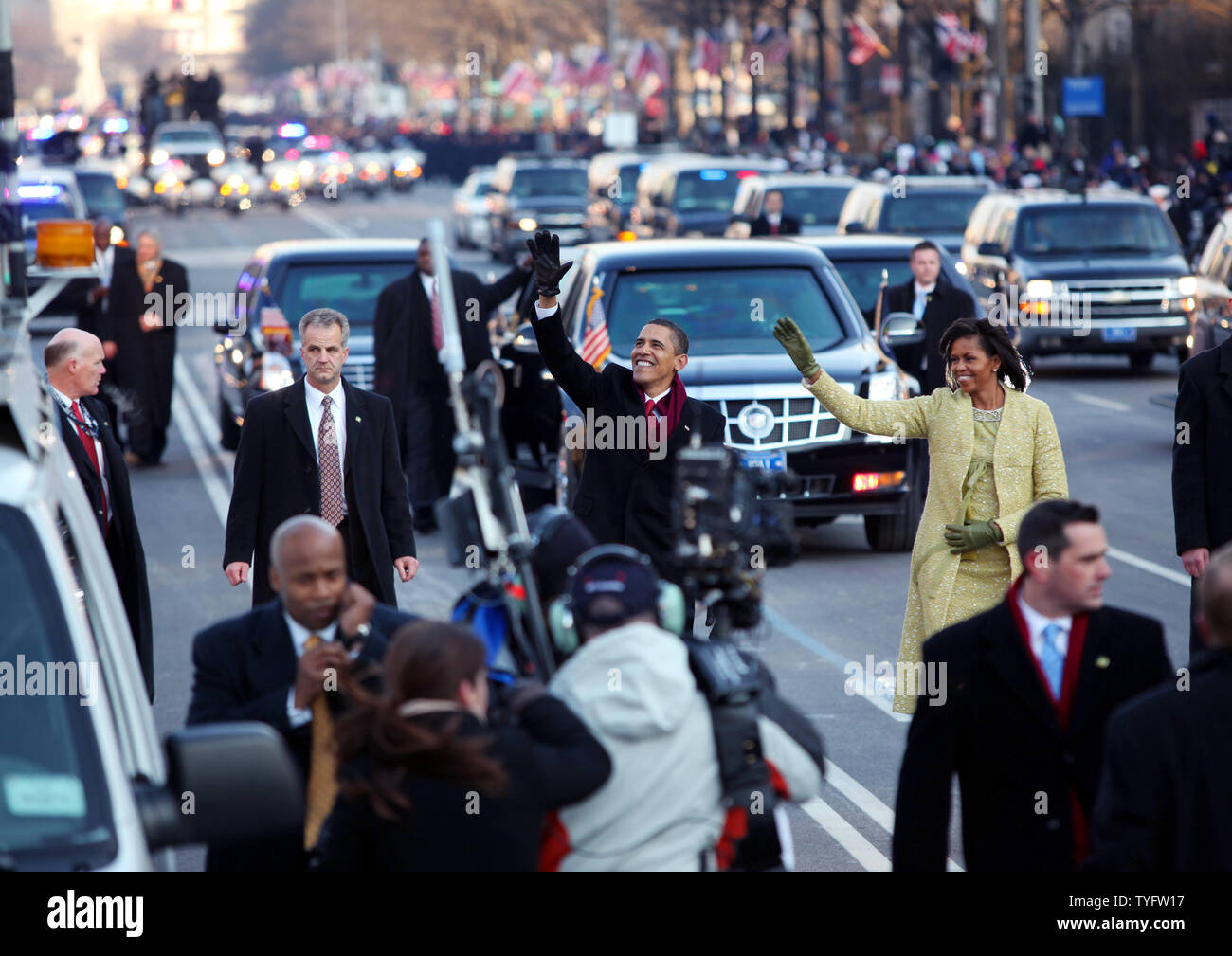 Barack Obama and Michelle Obama wave while walking the parade route ...