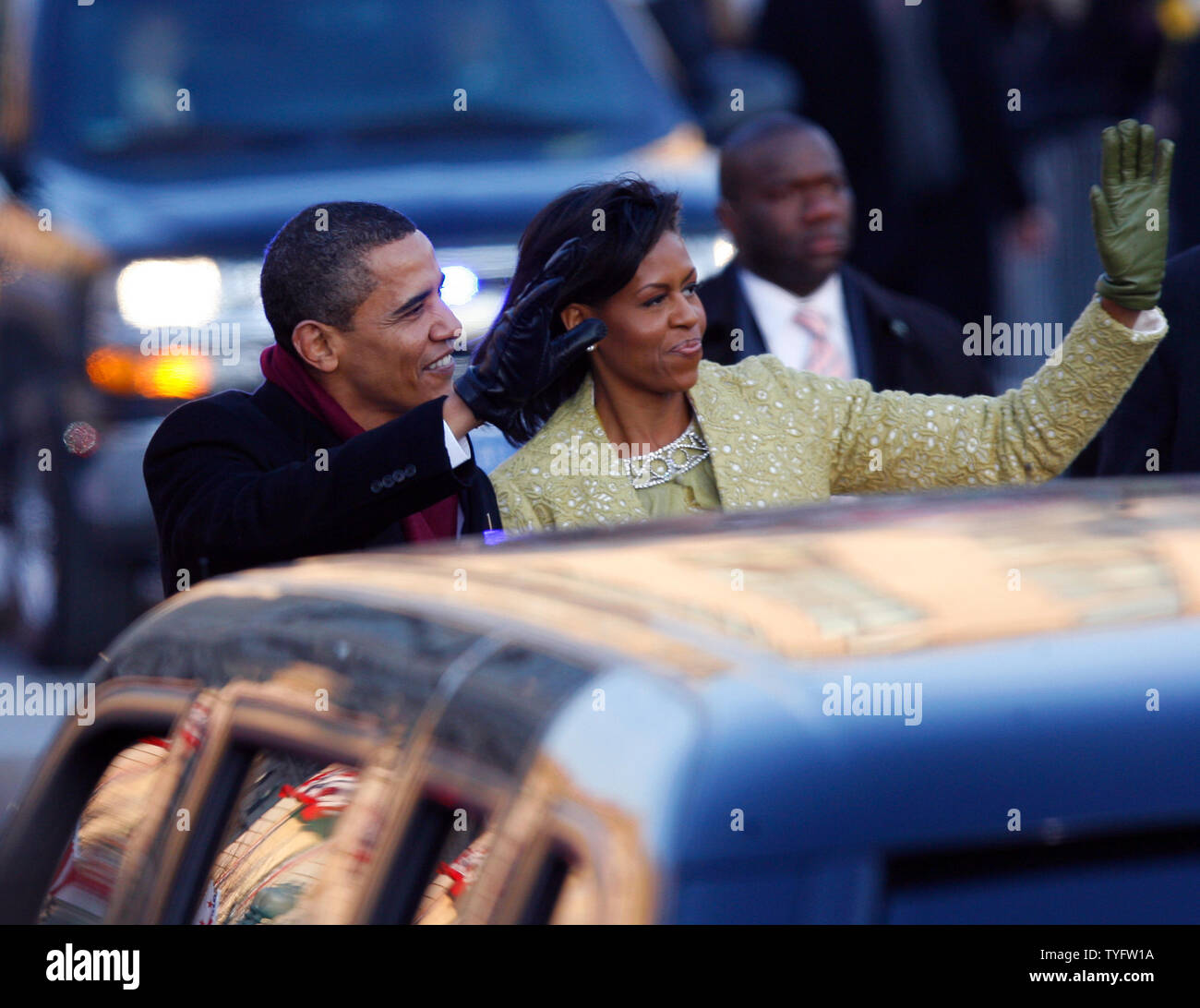 Barack Obama and Michelle Obama wave while walking the parade route ...