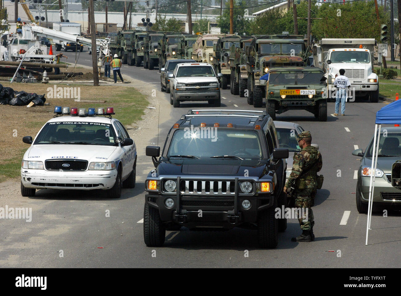 Long lines of civilian and military vehicles wait to enter the city of ...