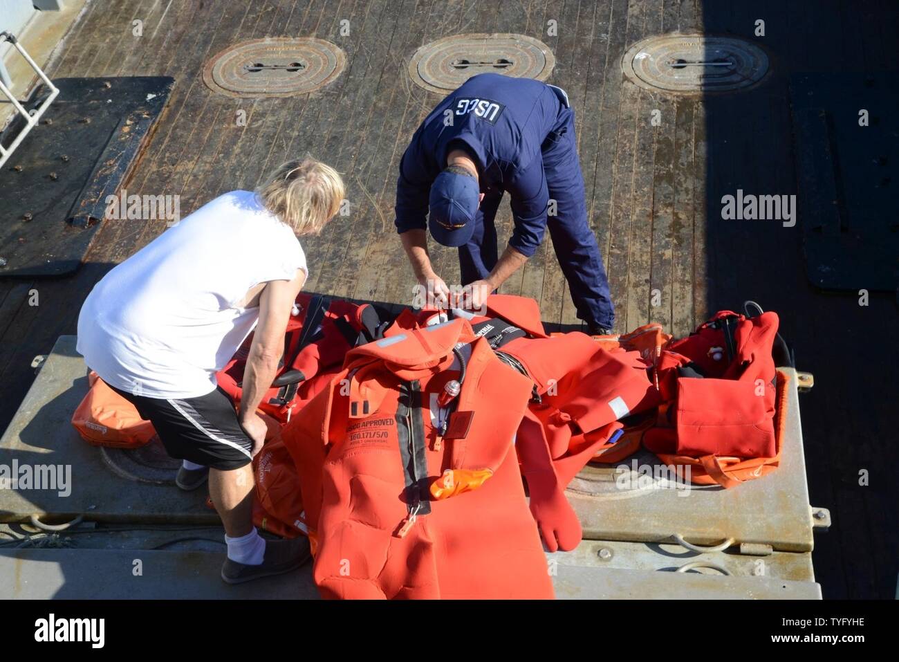 A Coast Guard Marine Environmental Specialist looks at survival suits ...