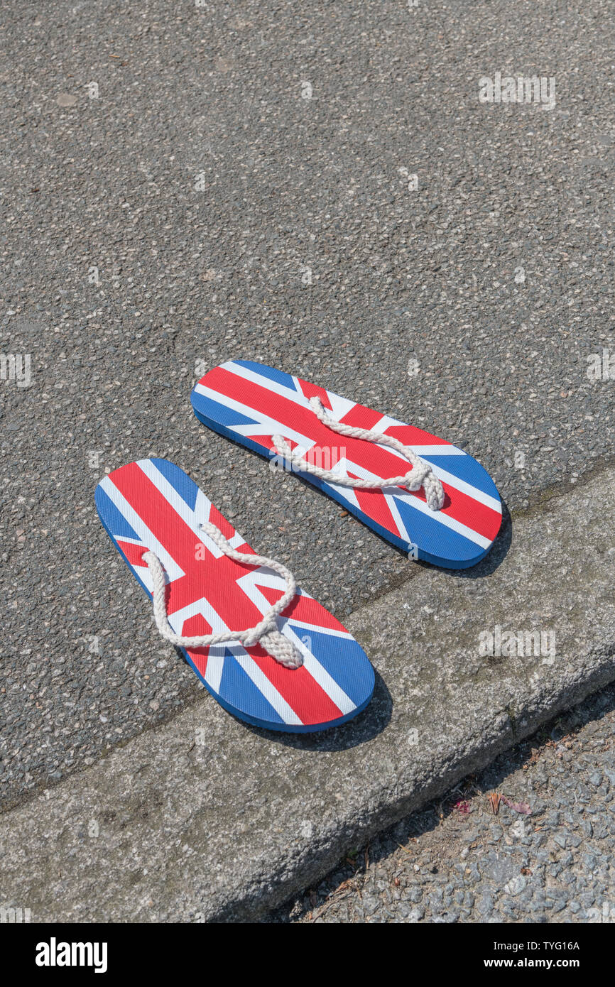 Union Jack flip-flops on pavement edge. Metaphor 2021 UK staycation ...