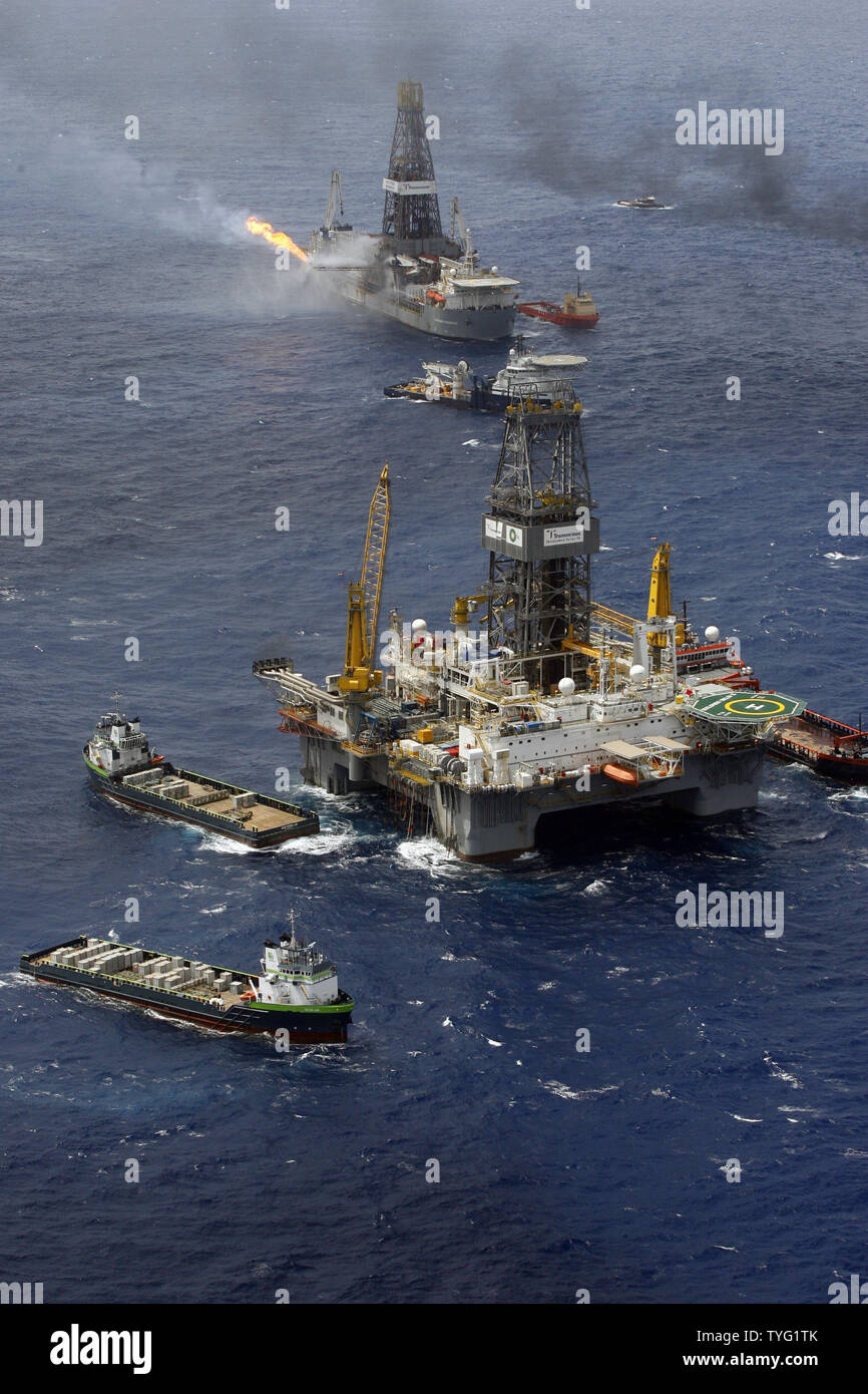 Workboats gather near a rig drilling a relief well, front, as the ...