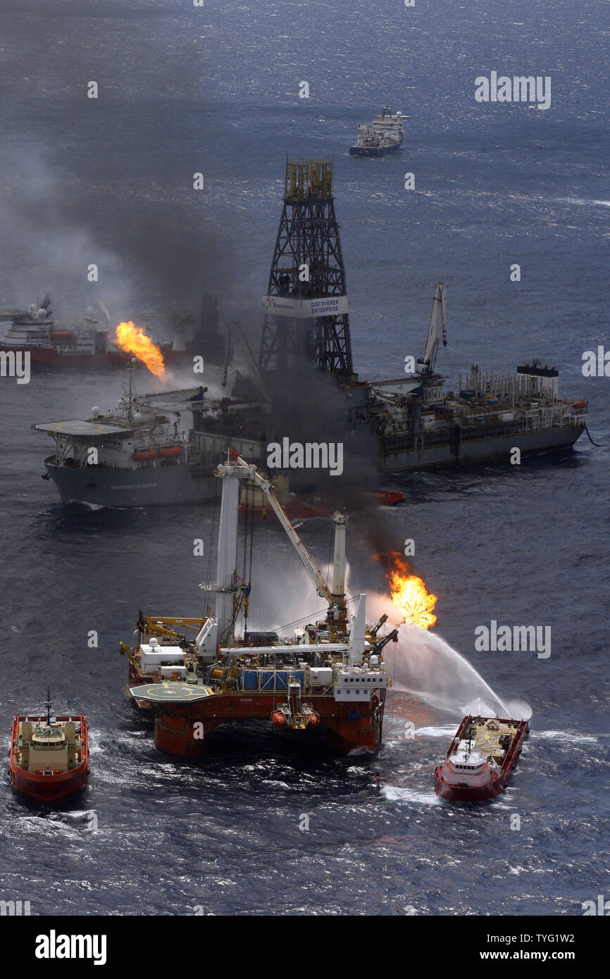 The Q4000 drilling rig, front, burns off oil and gas as the Discoverer ...