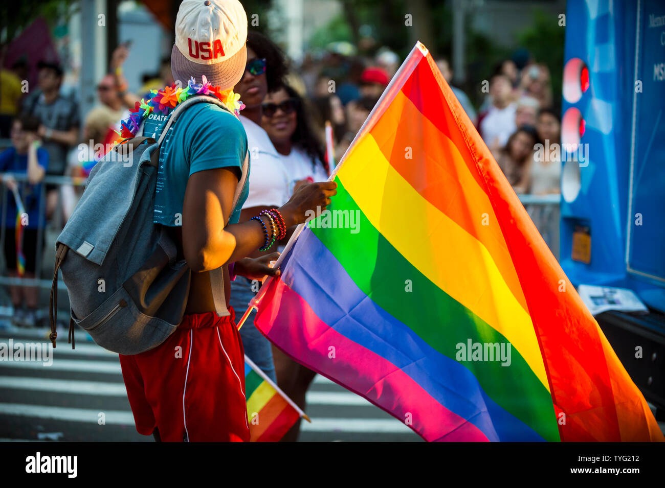 NEW YORK CITY - JUNE 25, 2017: A participant waves a rainbow flag in ...