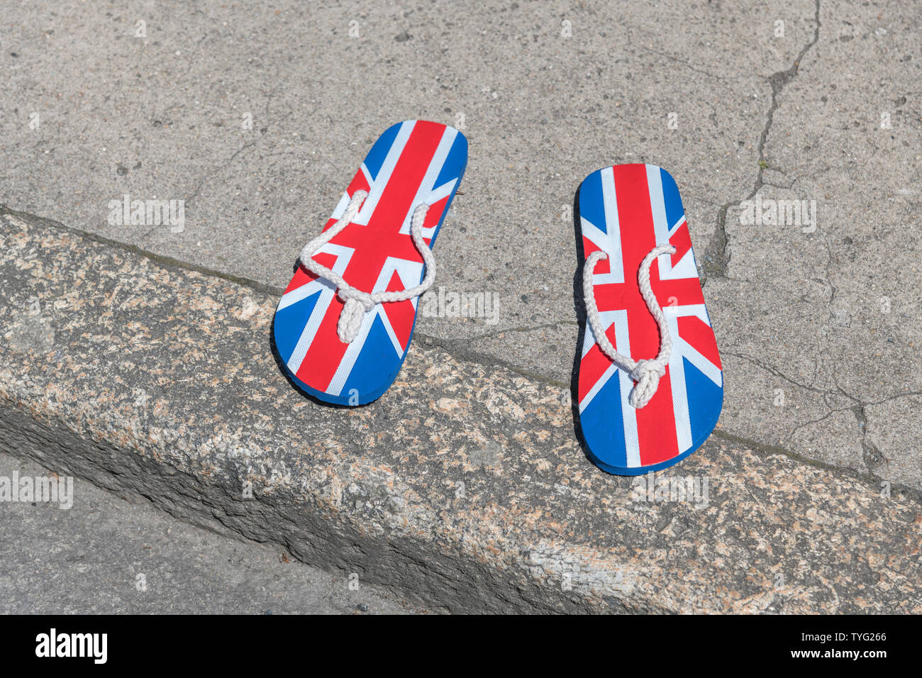 Union Jack flip-flops on pavement edge. Metaphor 2021 UK staycation ...