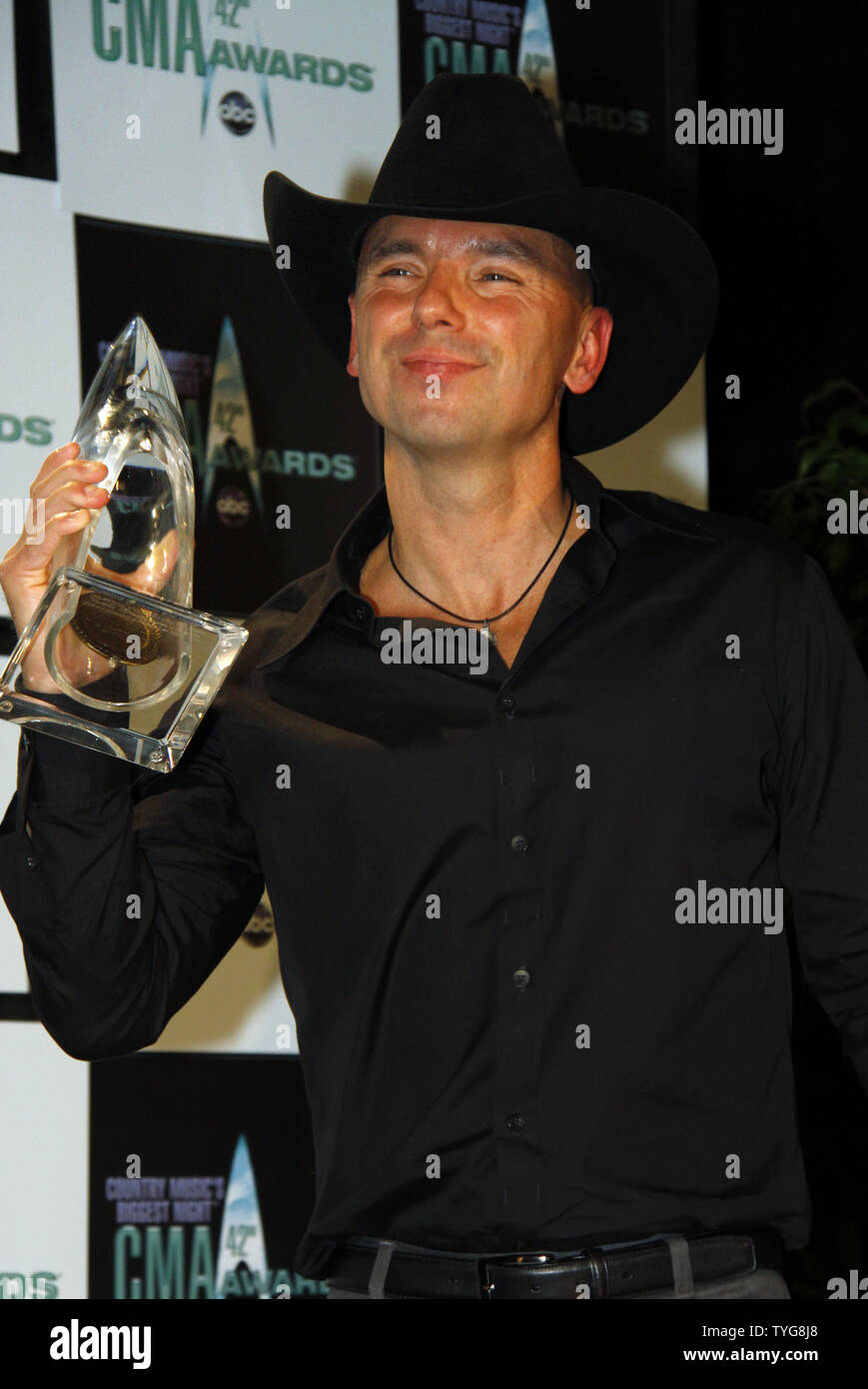 Kenny Chesney arrives in the press room with his award for Entertainer ...