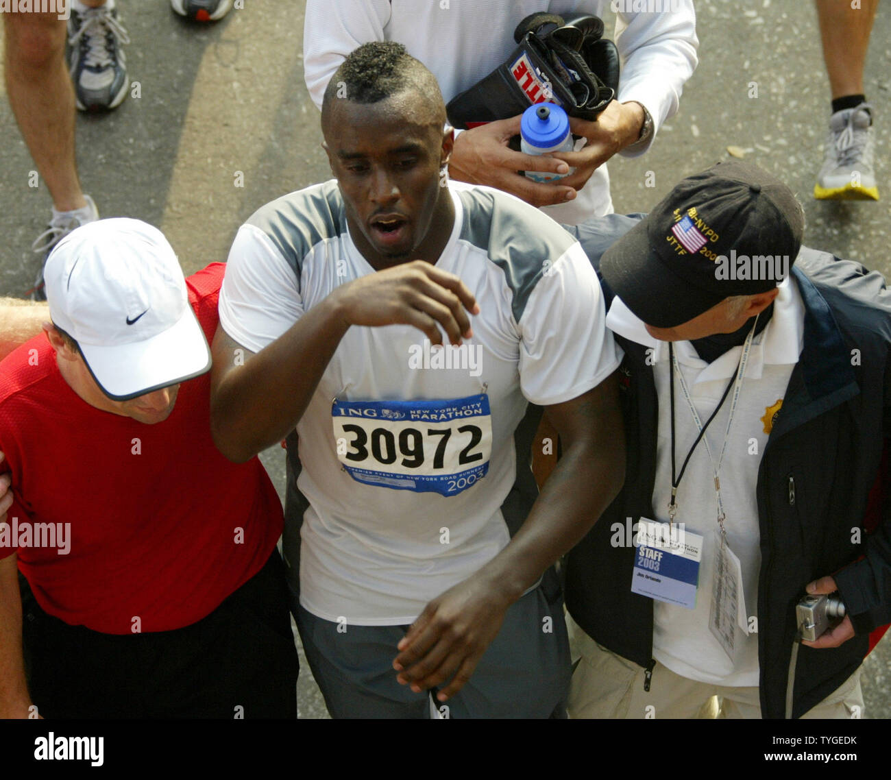 An exhausted Sean "P.Diddy" Combs is helped after crossing the finish ...
